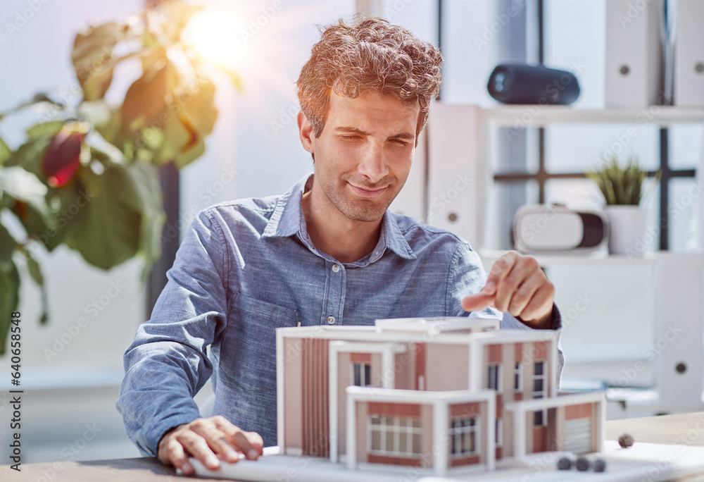 young caucasian engineer man making building model with the use of ...