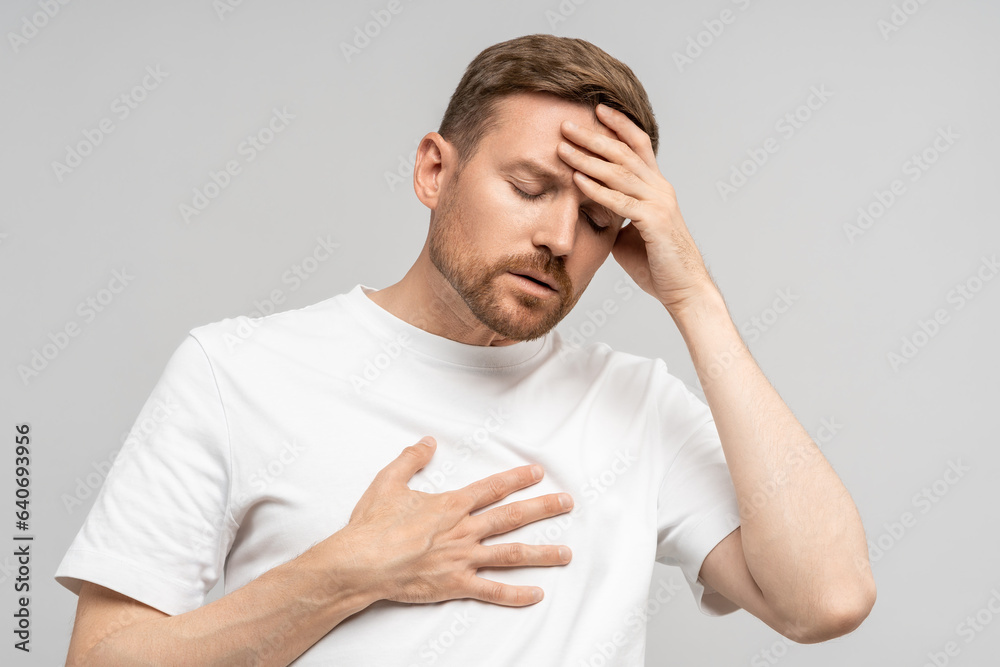 Unhealthy overwhelmed man with unhappy expression covered forehead hand ...