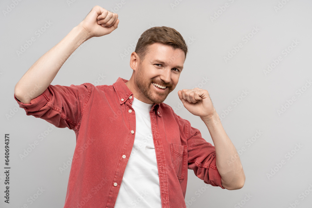 Smiling man celebrating success. Joyful carefree guy raised hands ...