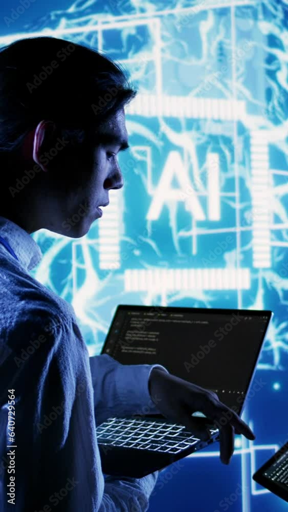 Vertical video IT team members programming scripts on laptop, employing AI machine learning ...