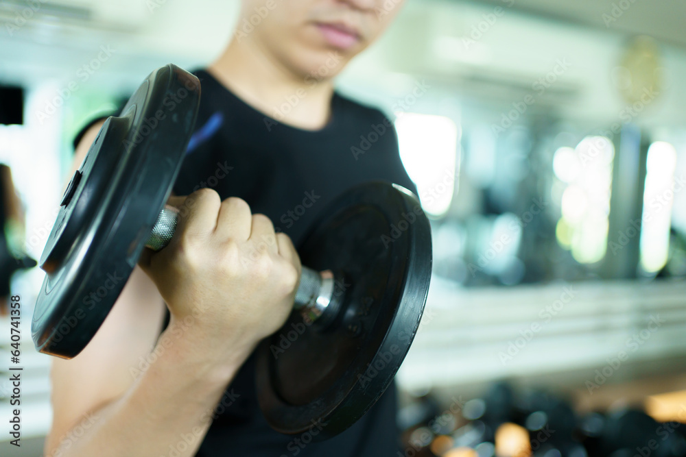 Active Asian sportsman doing a weight training exercise by lifting up a ...