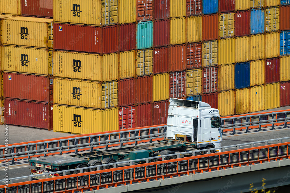 truck transports container through industrial seaport, warehouses with ...