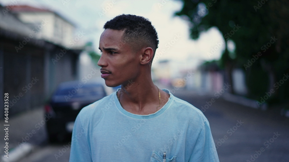 One confident young black man walking forward in street. Close-up face ...