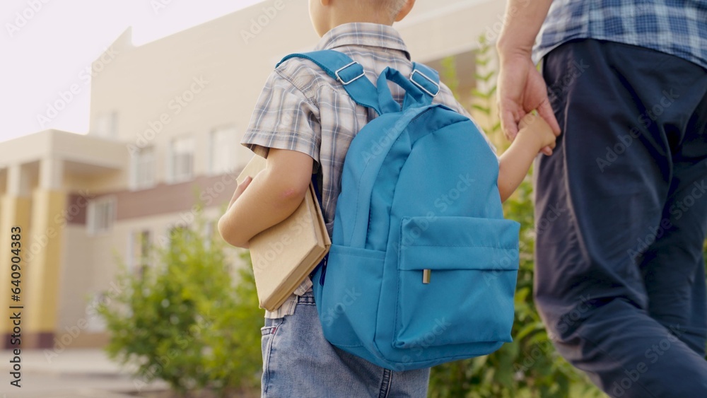 Foto de Child Schoolboy walking down street with backpack, holding his ...