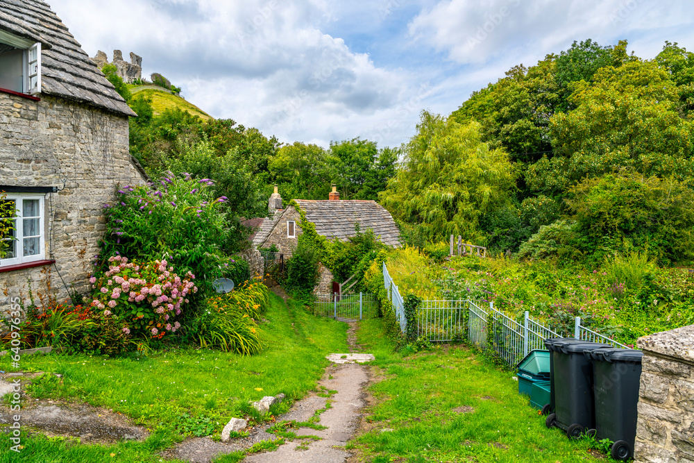 Picturesque stone cottages lie under the medieval hilltop ruins of ...
