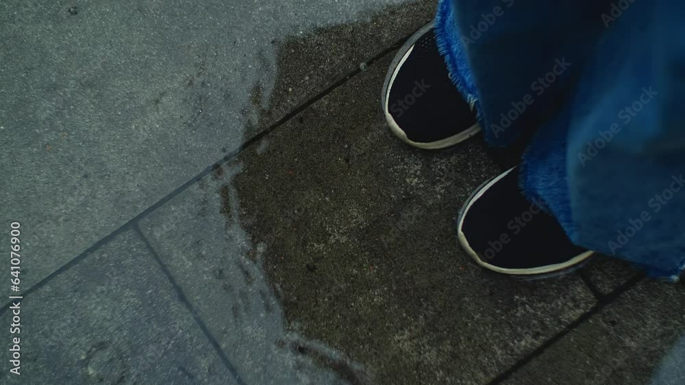 Jumping in the puddle. Woman steps in a muddy puddle of rainwater ...