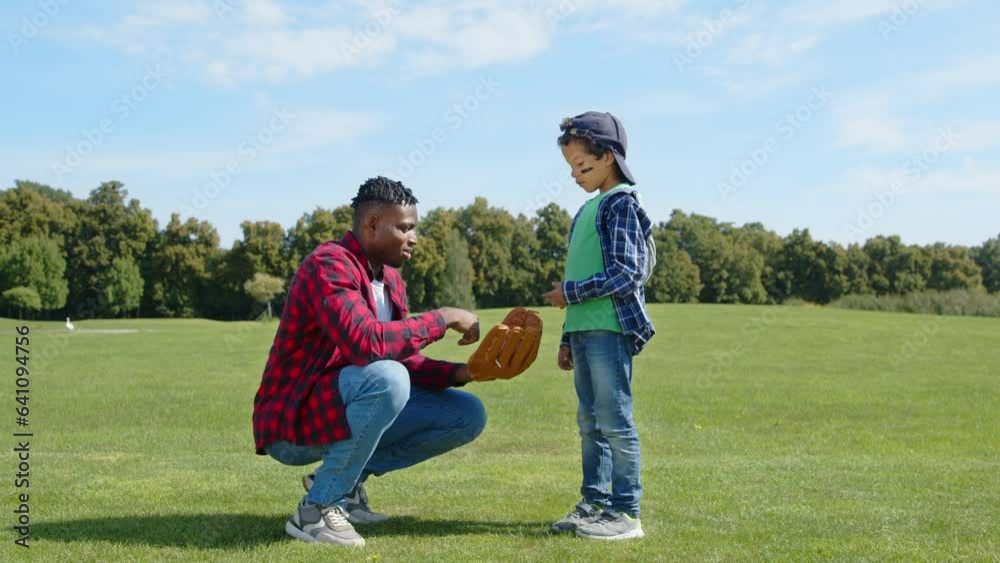 Caring affectionate handsome African American dad with baseball glove ...