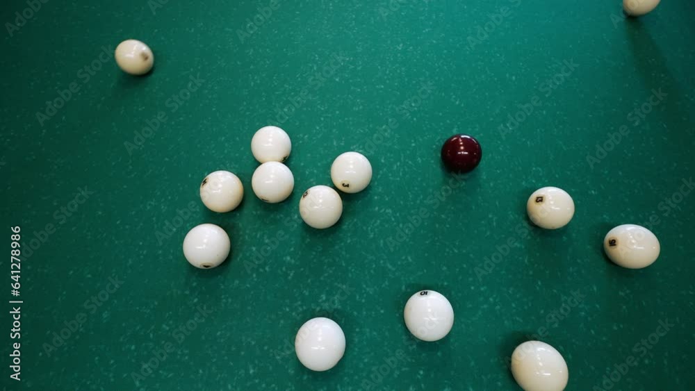 top down of red cue ball hits triangle of white balls in a russian ...