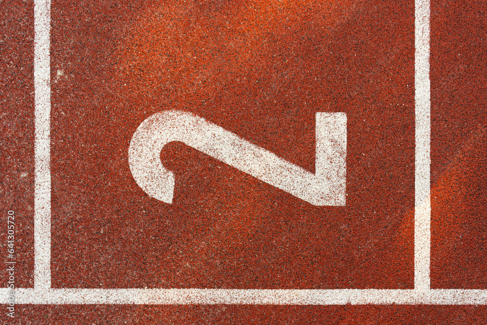 Running track lane number, starting line sign. Surface with lines and ...