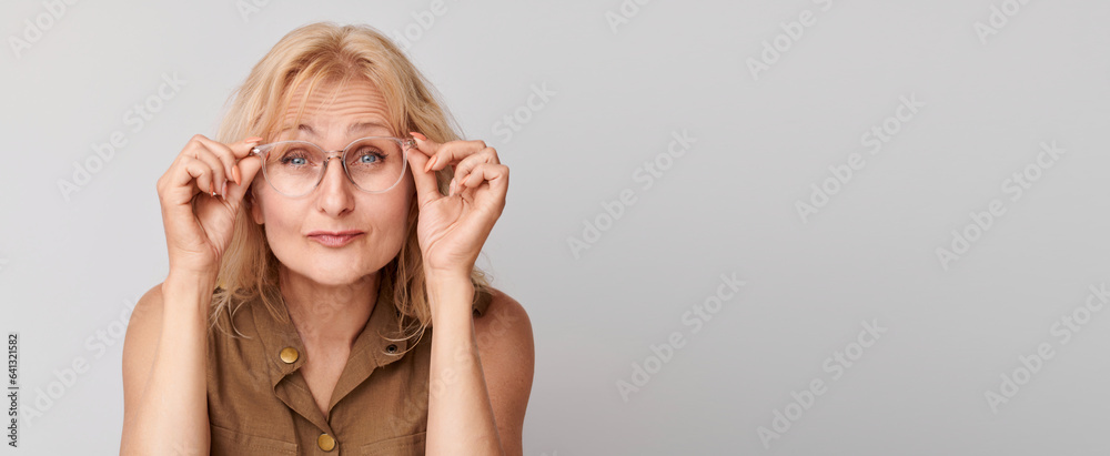 Portrait of 50 year old lady squinting in glasses isolated on white ...