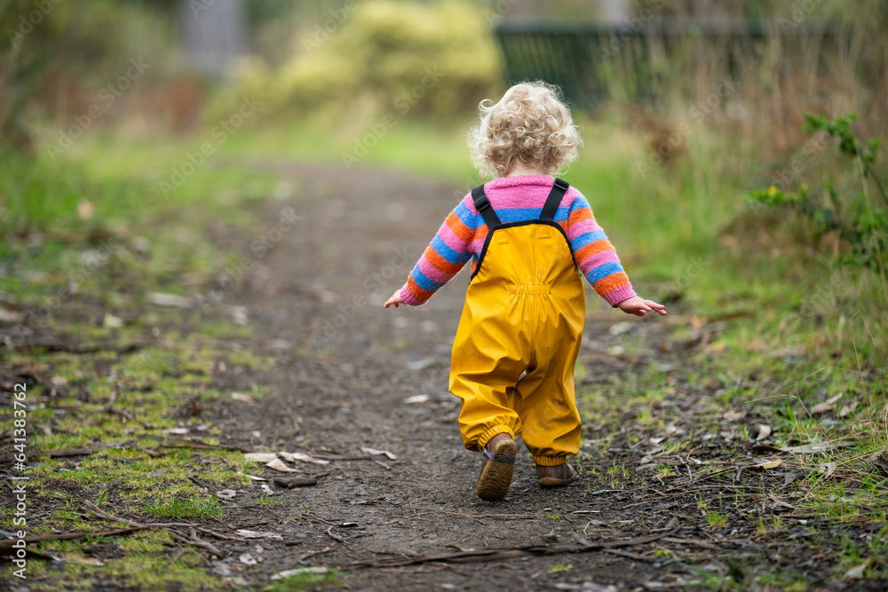 baby running down a path in yellow overalls Stock Photo | Adobe Stock