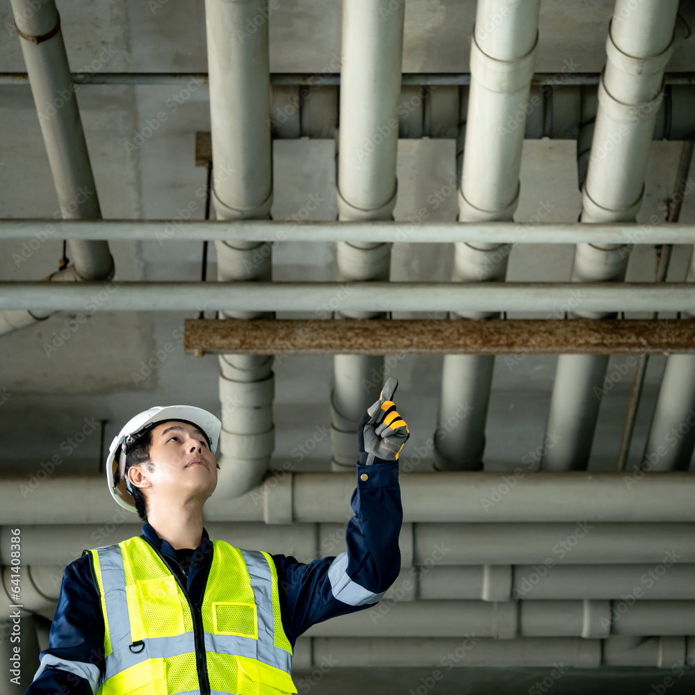 Asian male building inspection engineer pointing at plumbing piping ...