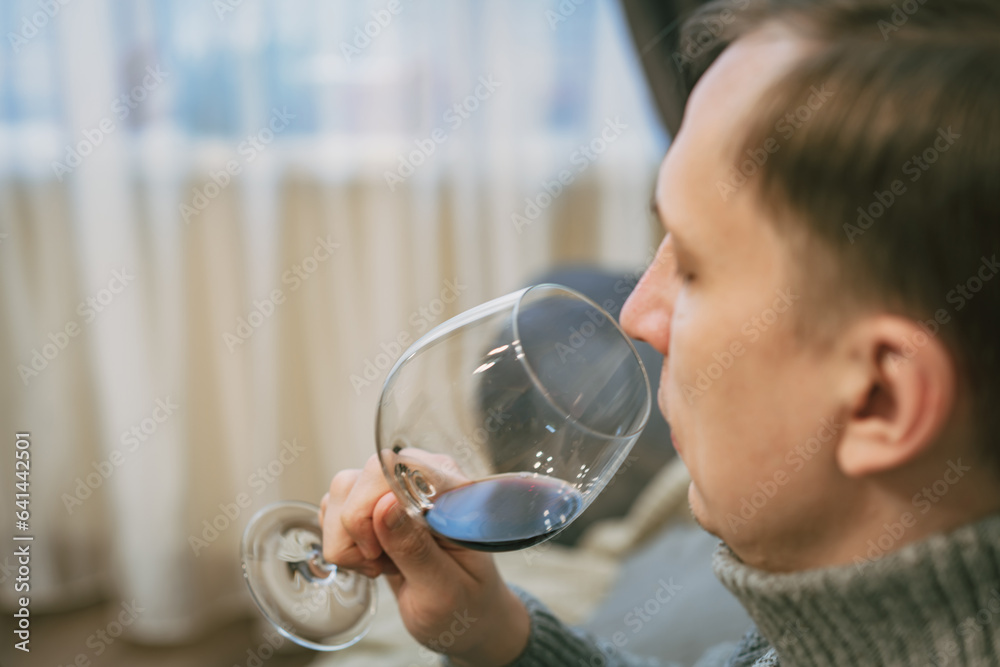 Relaxed serene rich lonely middle aged single man drinking red wine ...