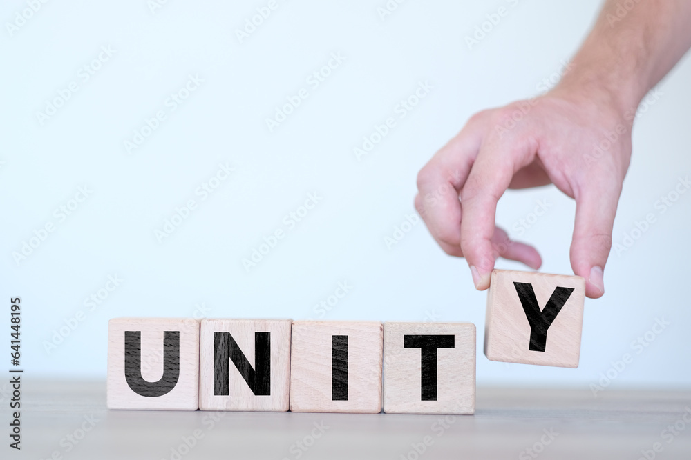 Man ordering unity word on wooden block cubes, collaboration or team ...