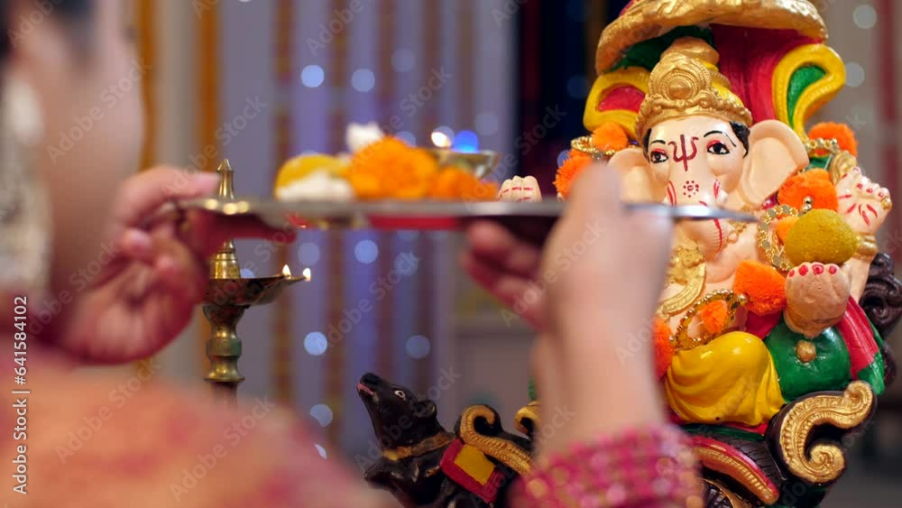 Overhead shot of an Indian female worshipping Lord Ganesha with Puja ...