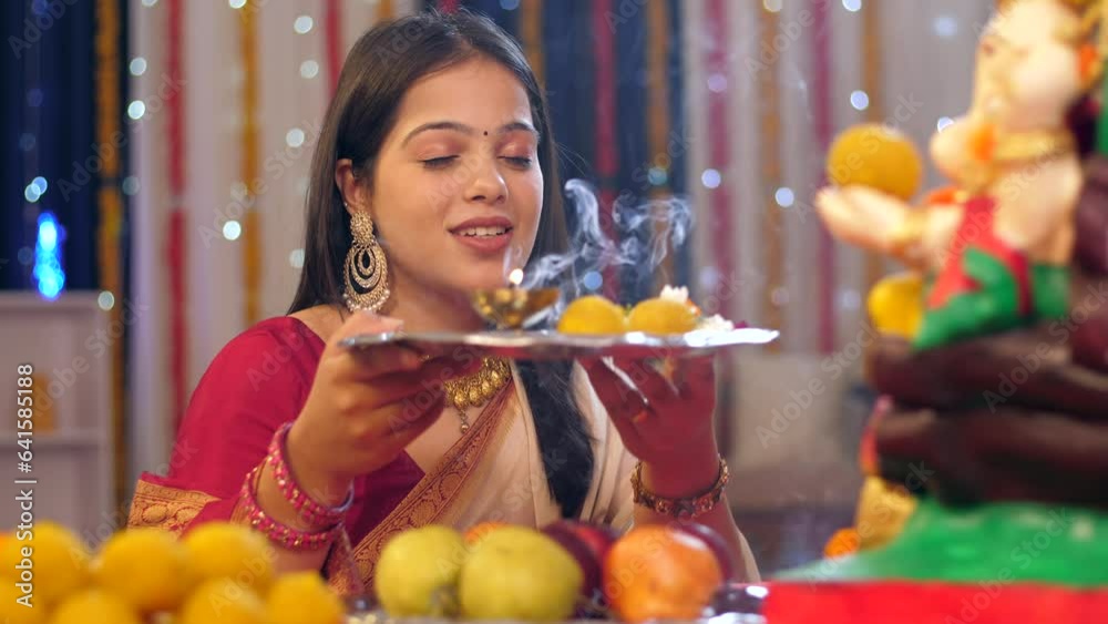 Indian woman worshipping Lord Ganesha with pooja ki thali - festival ...