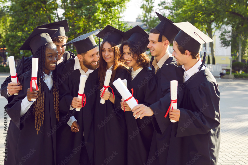 Group of seven college or university students having fun on graduation ...