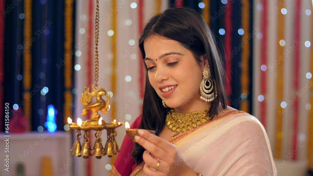 Vidéo Stock Happy Indian woman lighting diyas at home with Diwali ...