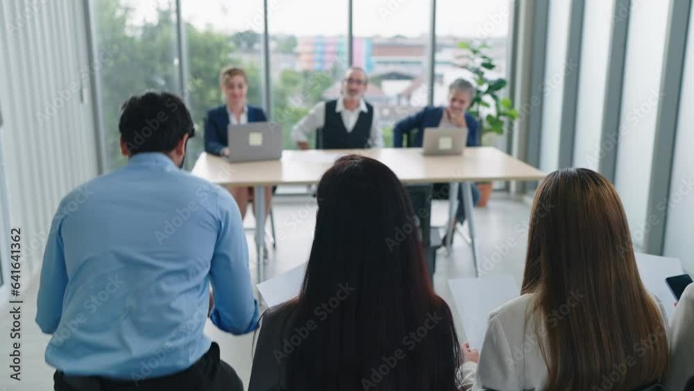 A man giving resume and shaking hands with three members of management ...