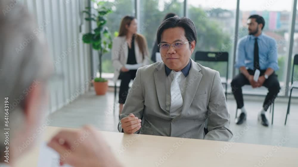 Asian candidate man sitting and answering interview questions with team ...