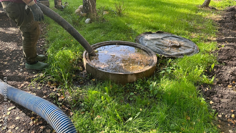 Pumping poop out of a cesspool. Cleaning the sewer garden well. Workers ...