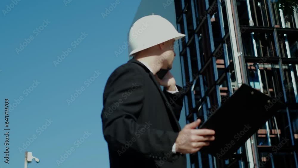 Male civil engineer contractor in safety helmet and jacket standing on ...