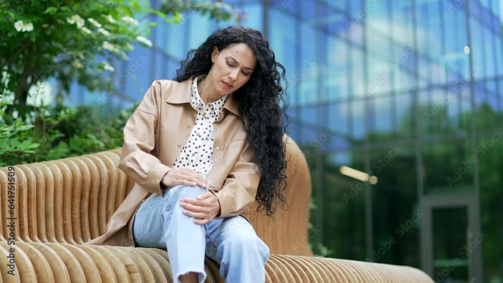 Young female employee suffers from painful severe knee joint pain while ...