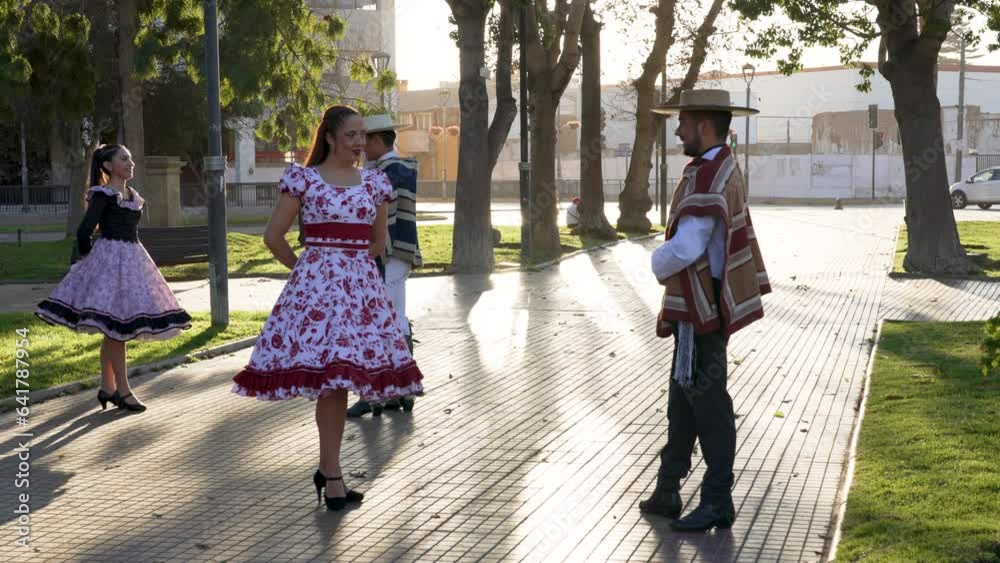 Adult men in huaso costumes lead the women by the arm to dance the ...
