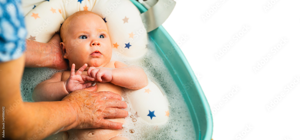 A grandmother bathes her granddaughter in foam water. Toddler girl ...