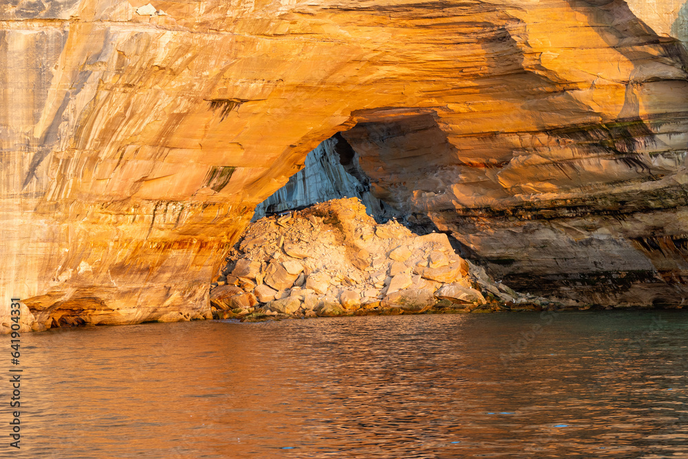 Collapsed rocks covered in birds in a natural arch along Pictured Rocks ...