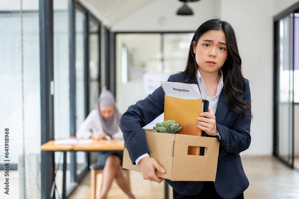 Foto de Sad Asian female office worker being fired from her boss ...