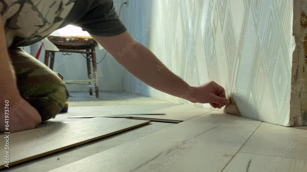 Installation of a laminate board by a professional worker. Floor repair ...