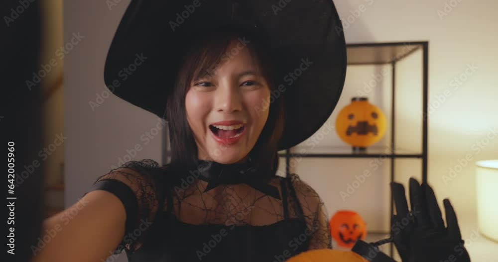Female influencer wearing witch costume and live streaming at home. She ...