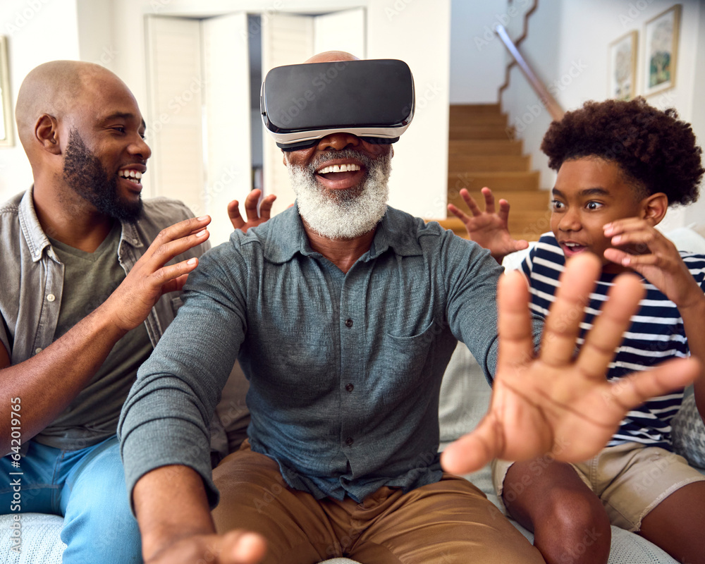 Grandfather Wearing VR Headset As Multi-Generation Male Family Sit On ...