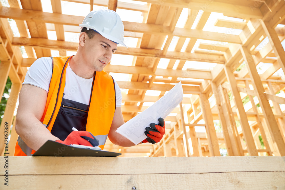 Side view of male architect, engineer, builder standing, constructing ...