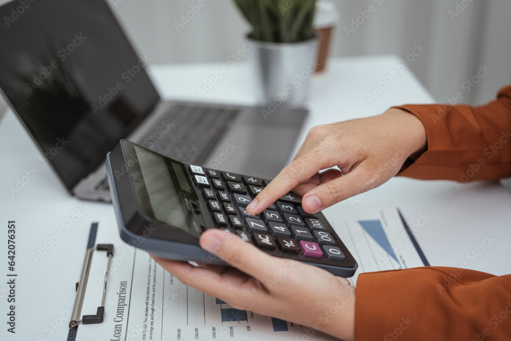 Close up hands of woman in brown formal suit checking bills, taxes ...