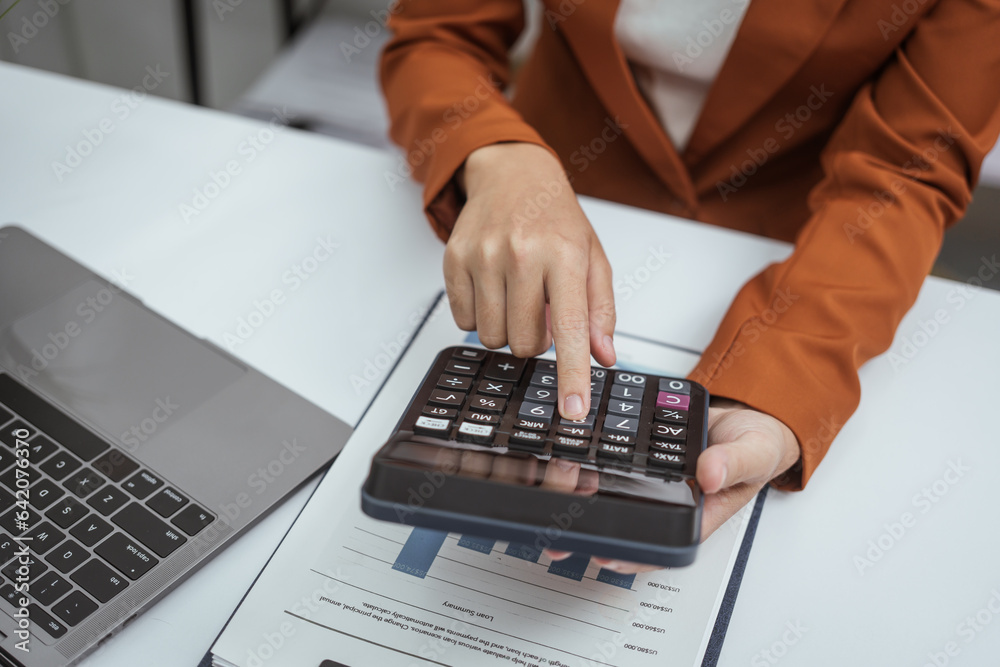 Close up hands of woman in brown formal suit checking bills, taxes ...