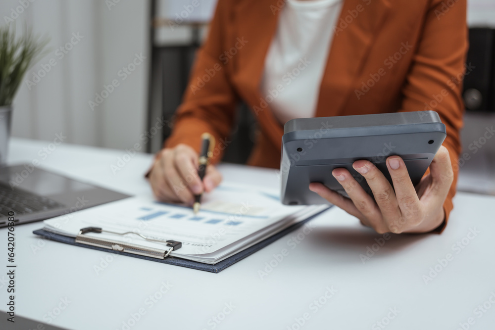 Foto de Close up hands of woman in brown formal suit checking bills ...