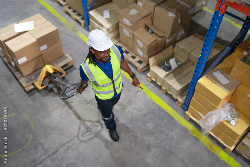Male worker pulling pallet truck loading package boxes stacking in ...