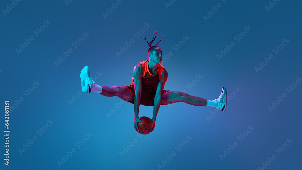 Twine in air. Sportive young guy, basketball player in motion during ...