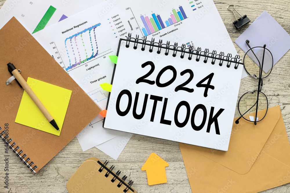OUTLOOK 2024 stationery and calculator on financial chart. text on ...