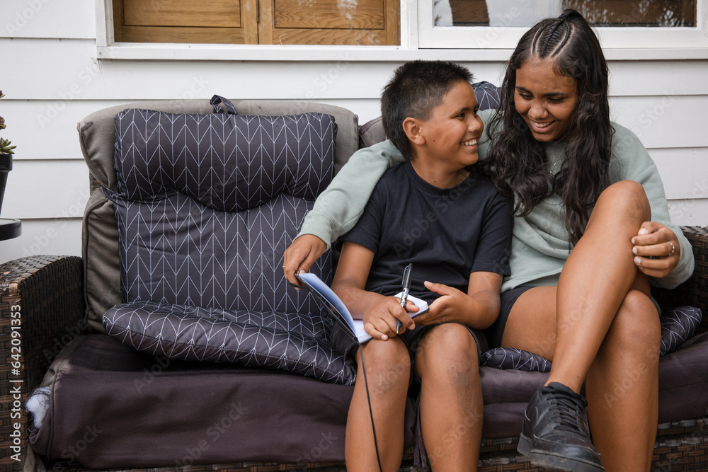 Aboriginal girl and young Aboriginal boy sitting together Stock Photo ...