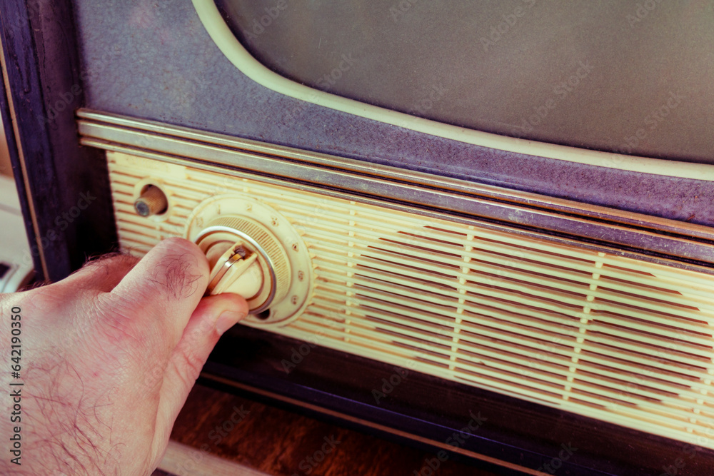 The hand changes channels on the retro old TV. Turning on of the ...