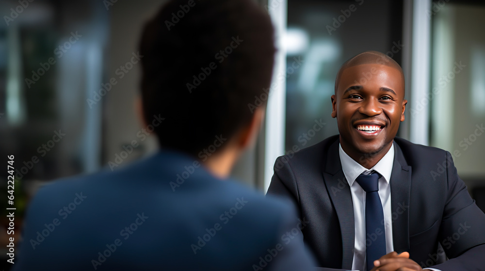 Man in a suit at a job interview at an office, sitting across the table ...