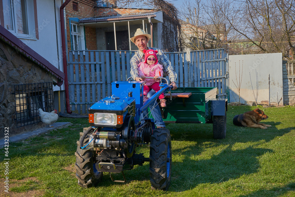 father and daughter on a tractor,a farmer with a little girl sitting on ...