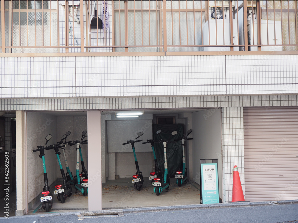TOKYO, JAPAN - February 28, 2023: A group of Luup rental e-scooters ...