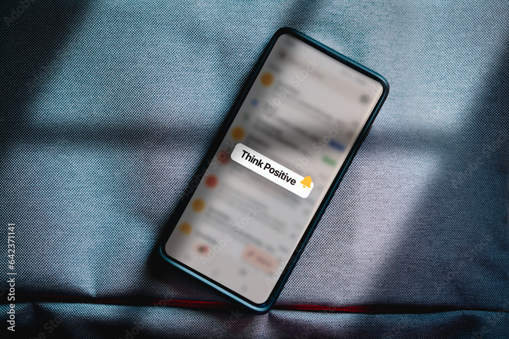Top view photo of smartphone with "think positive" quote notification ...