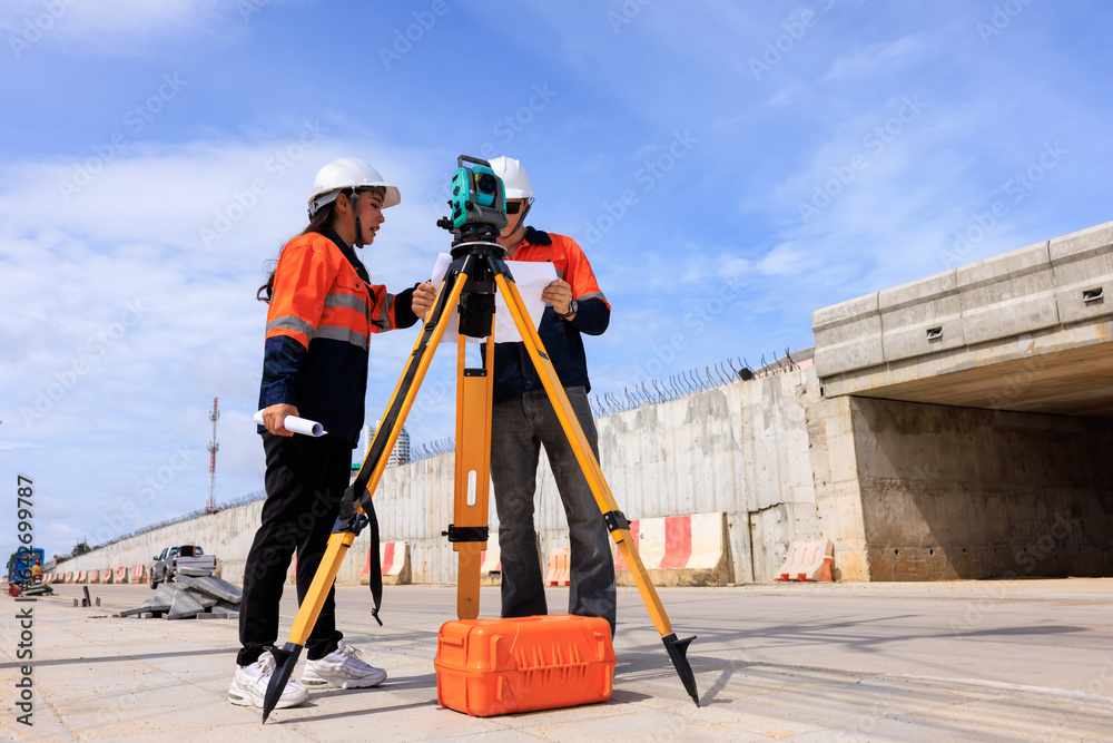 Engineer use theodolite equipment and looking blueprints construction ...