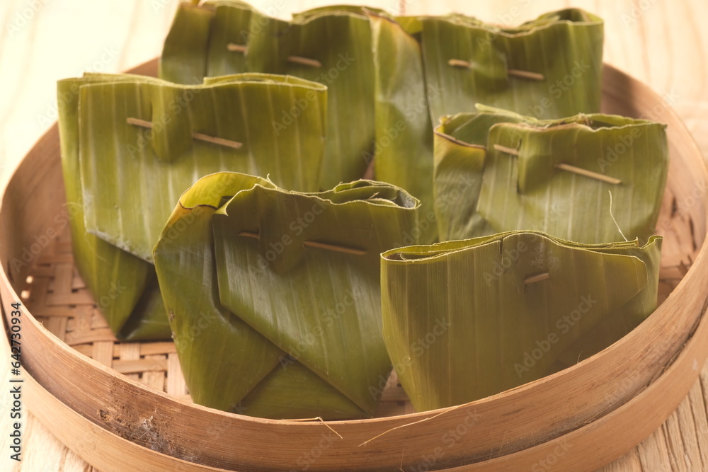 banana leaf wrapper on a woven bamboo container. in some Asian ...