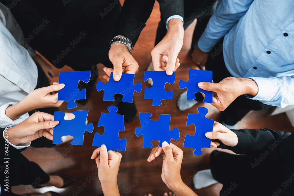 Top view multiethnic business people holding jigsaw pieces and merge ...